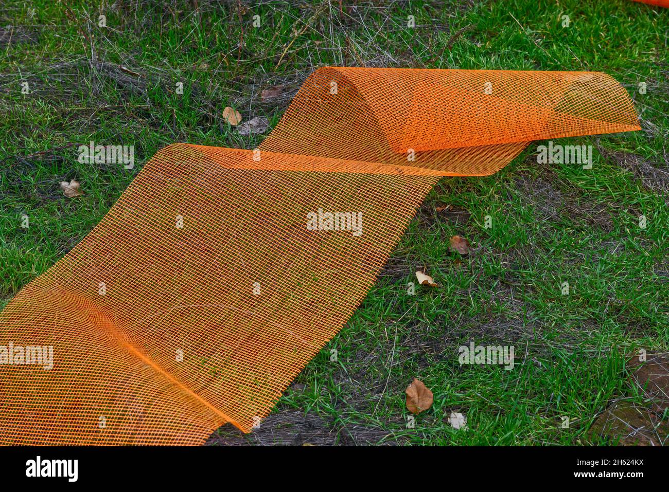 Rolled out bright orange fiber plastering mesh on the green grass Stock ...