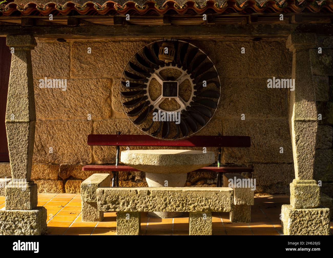 pergola with stone columns and inside a table and stone benches and ...