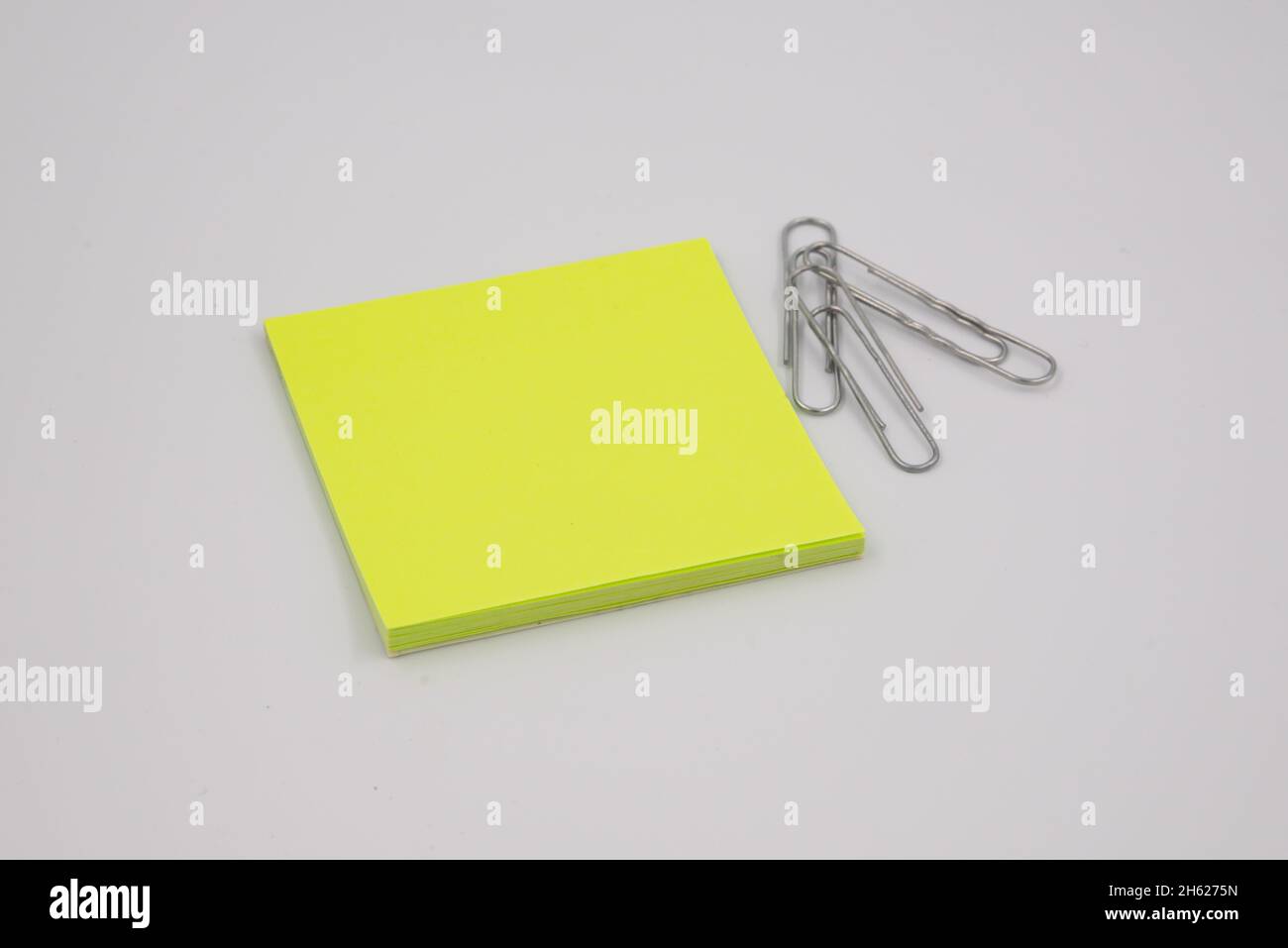 Neon yellow paper note with metal clips isolated on white Stock Photo ...
