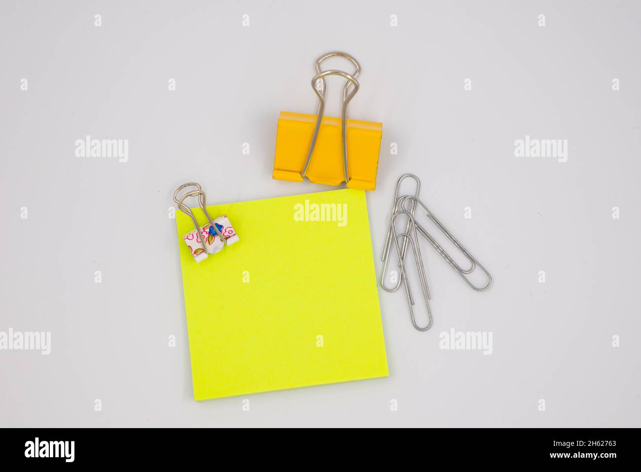 Neon yellow paper note with metal clips isolated on white Stock Photo ...