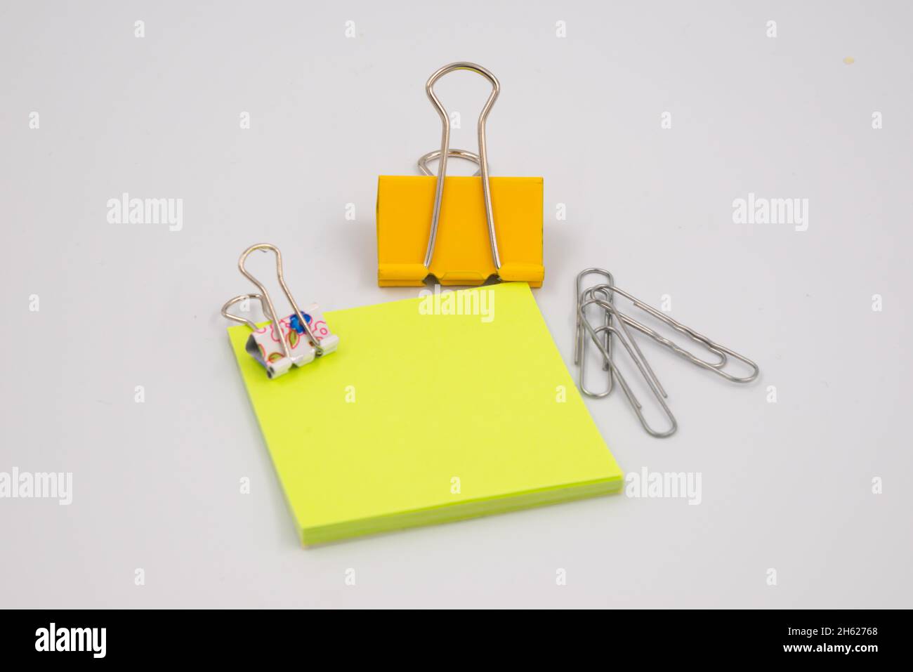 Neon yellow paper note with metal clips isolated on white Stock Photo ...