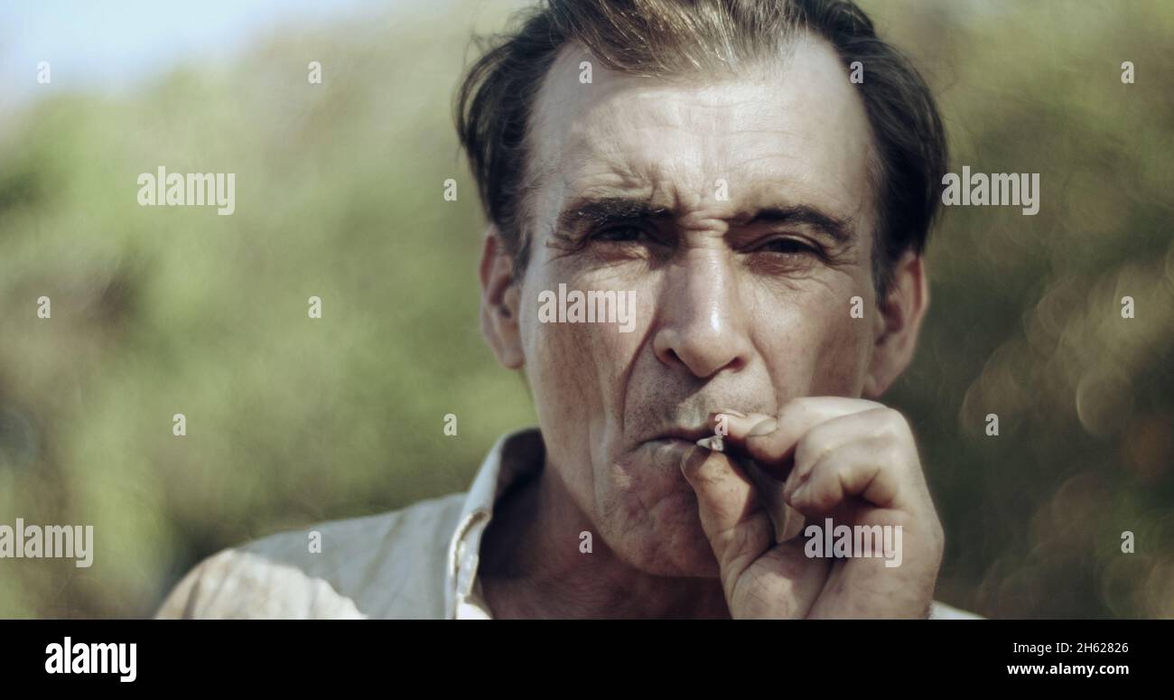 Farmer smoking a cigarette on the farm, straw cigarette Stock Photo - Alamy
