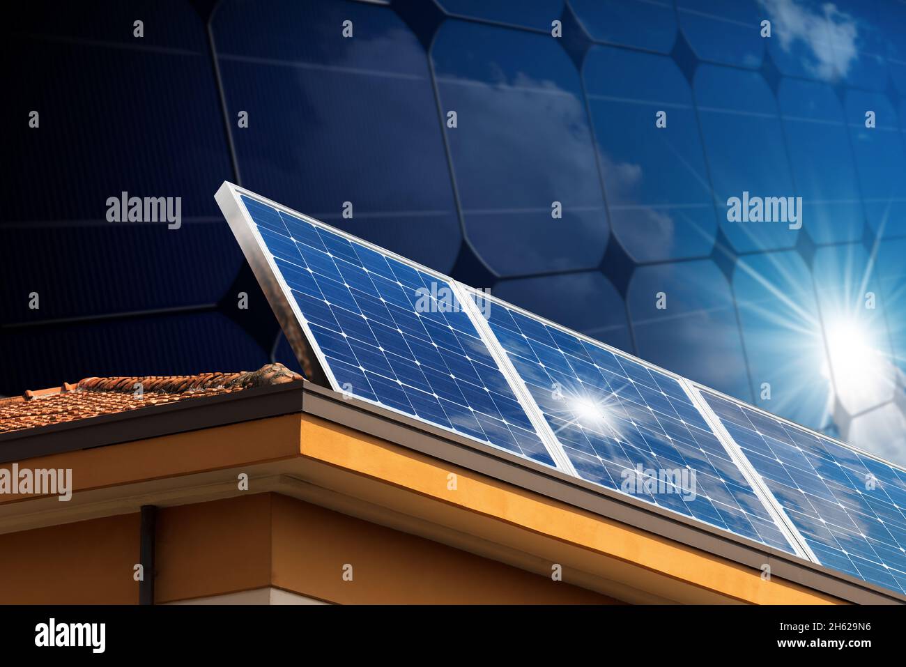 Close-up of a group of solar panels above the roof of a house, and a ...