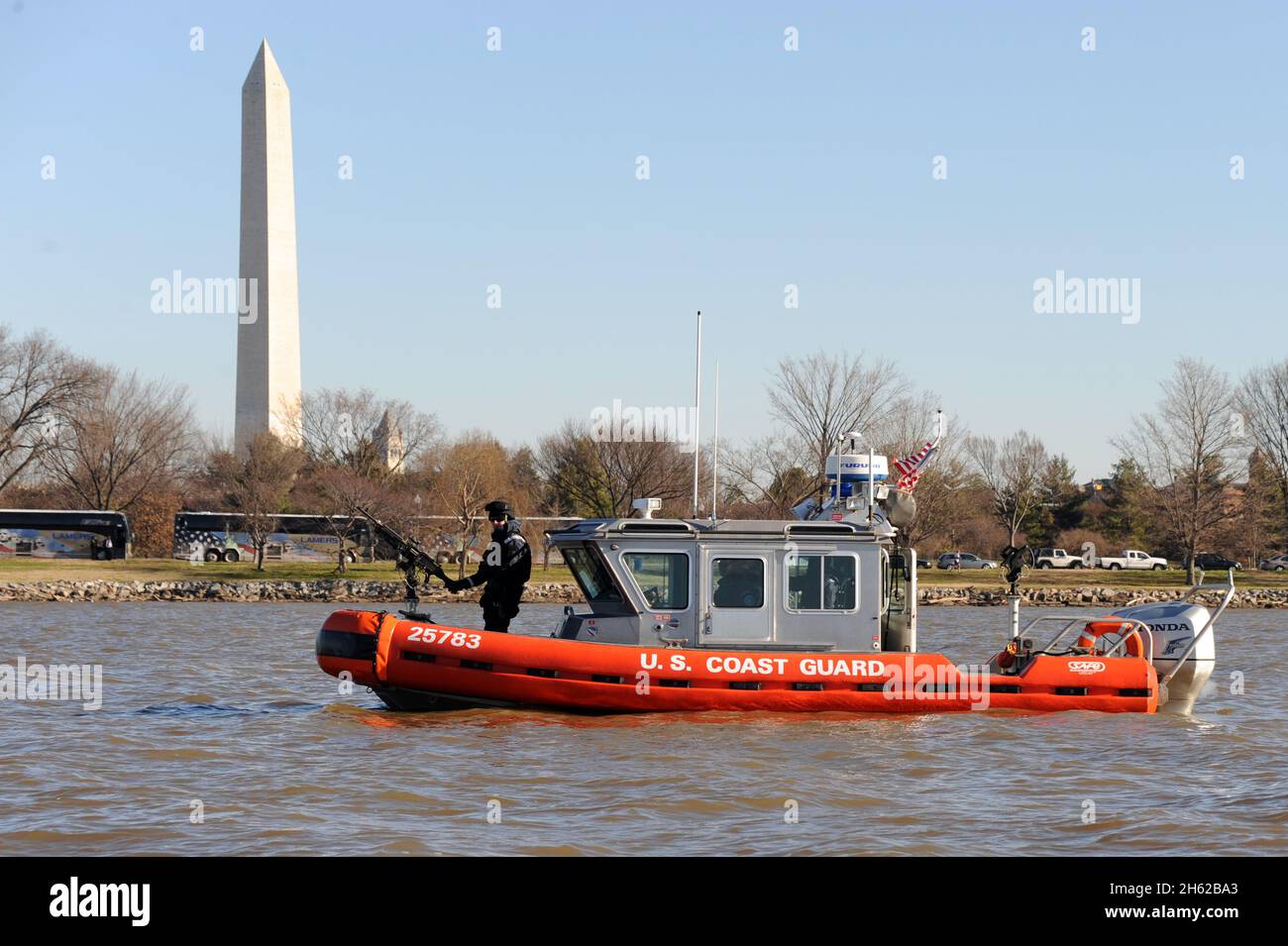 Reportage: A U.S. Coast Guard Petty Officer 2nd Class mans a mounted ...