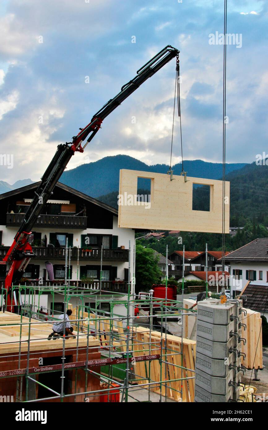 prefabricated part in timber construction is hoisted into new building ...