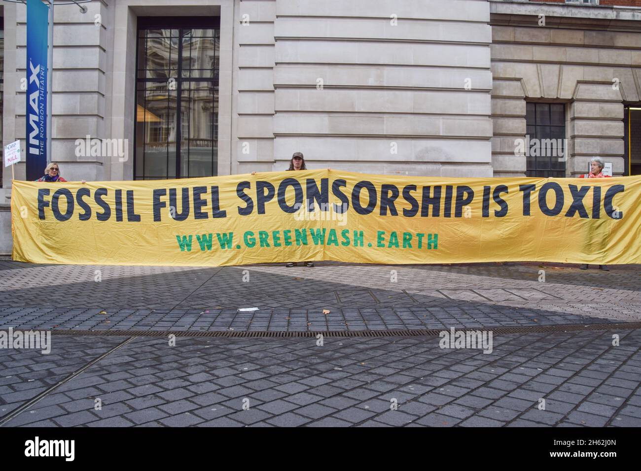 Protesters hold an anti- fossil fuel banner expressing their opinion ...