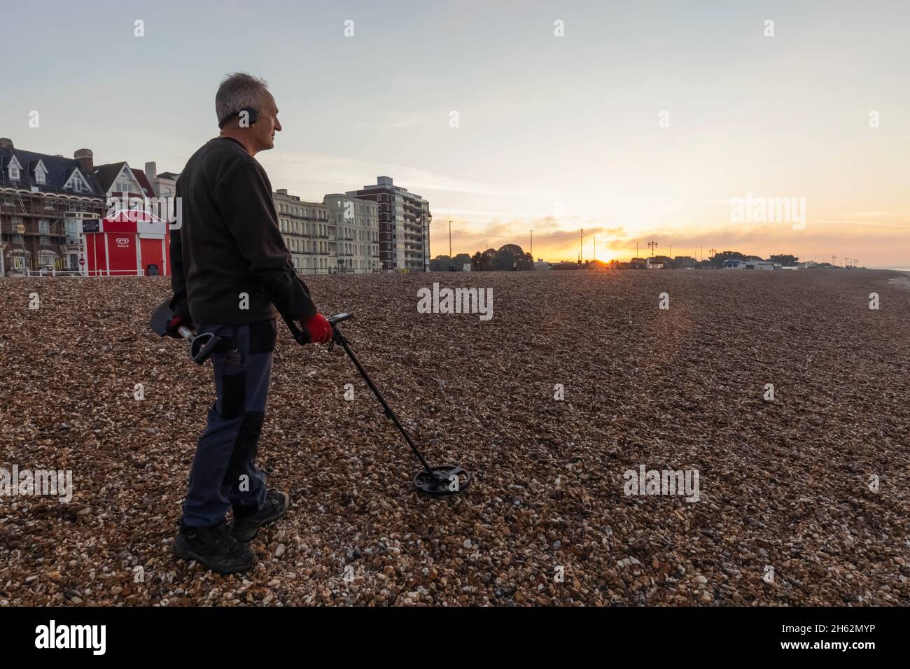Man metal detecting on beach and southsea pier hi-res stock photography ...