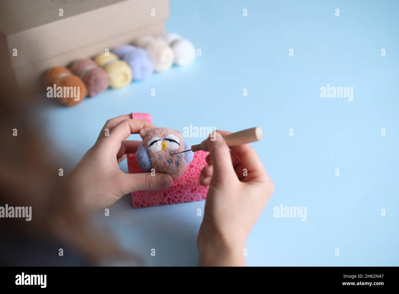 Female hands to create a toy by felting wool. Process of dry felting ...