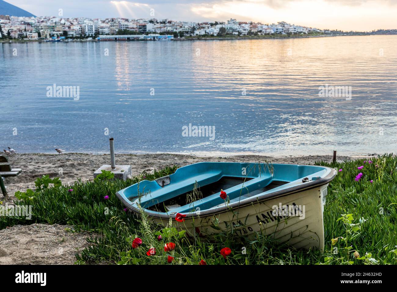 a boat on the land in front of a channel of water from the ocean Stock ...