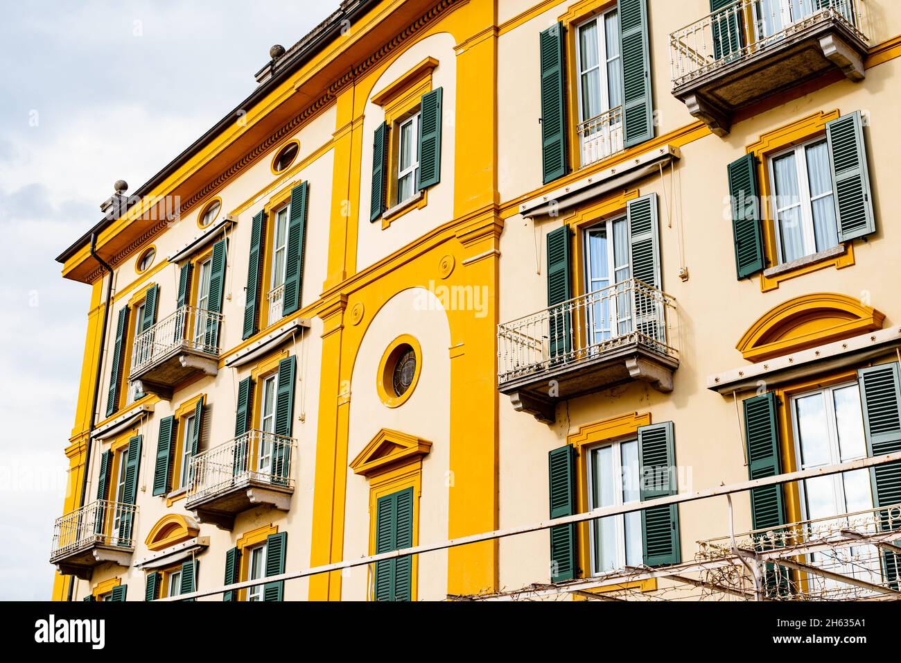 Colorful facade of the house with shutters and small balconies. Varenna ...
