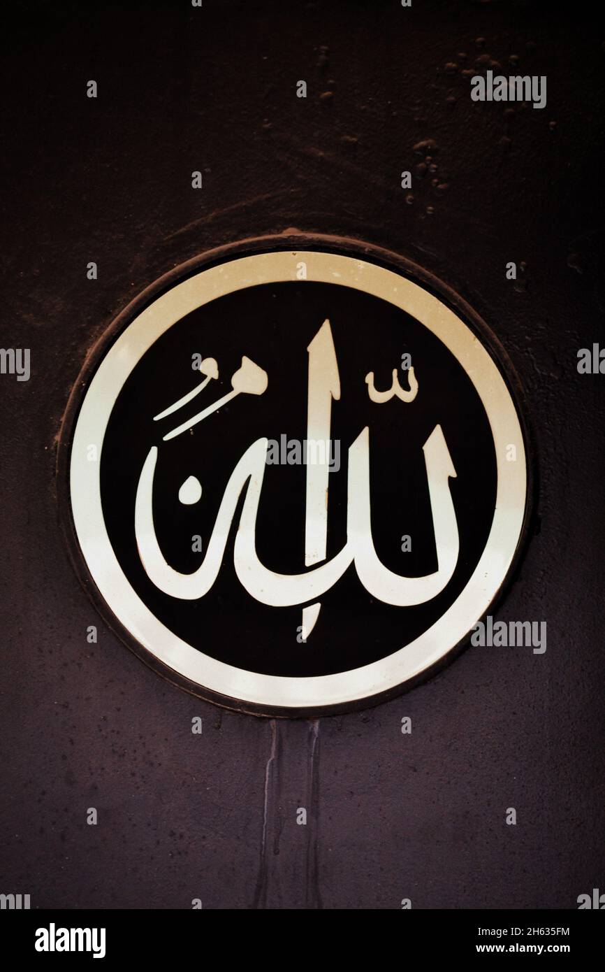 Vertical closeup shot of an "Allah" writing in Arabic in a circle on a ...