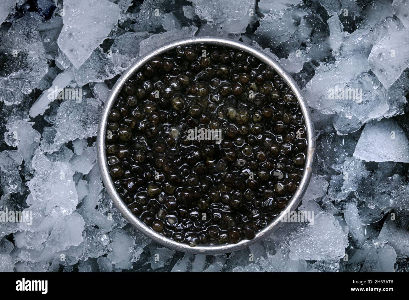 Caviar in a metal box on ice seen from above on black background Stock ...