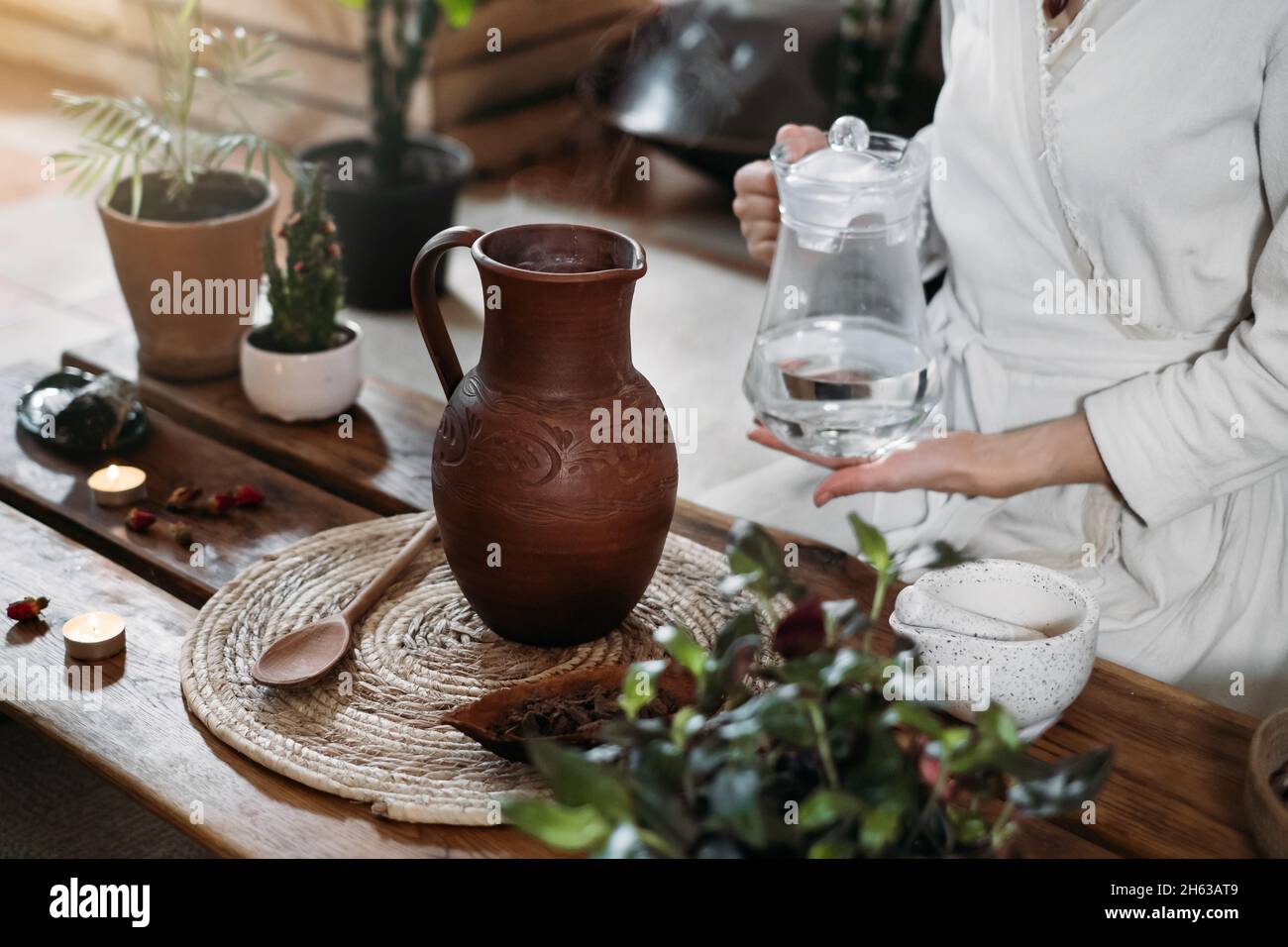Pouring water into jug with cacao. Preparing ceremonial cocoa in ...