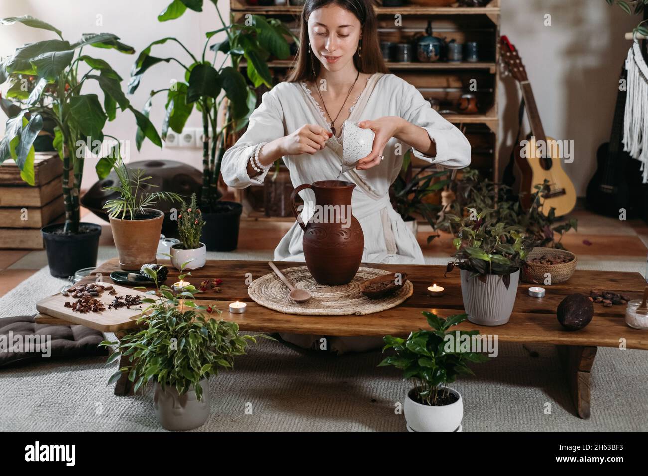 Pouring water into jug with cacao. Preparing ceremonial cocoa in ...