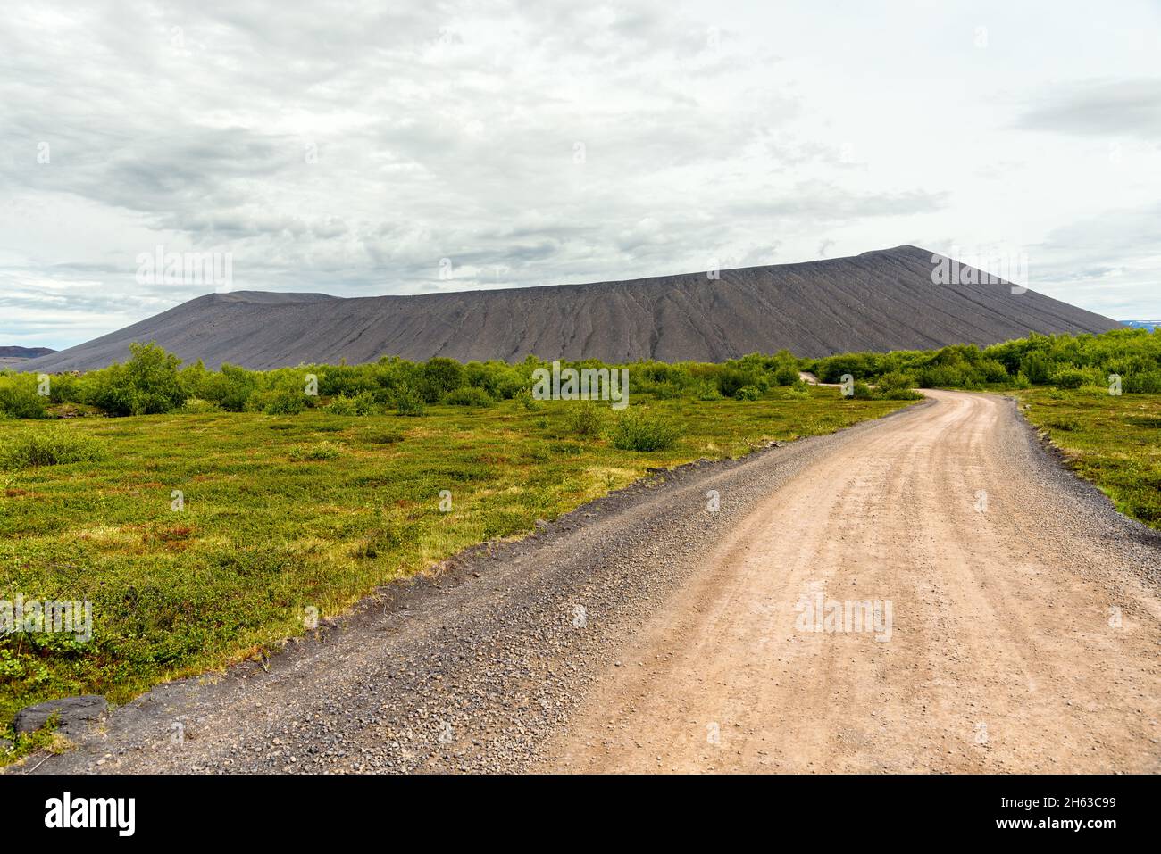 Empty gravel road to a volcano in Iceland and cloudy sky Stock Photo ...