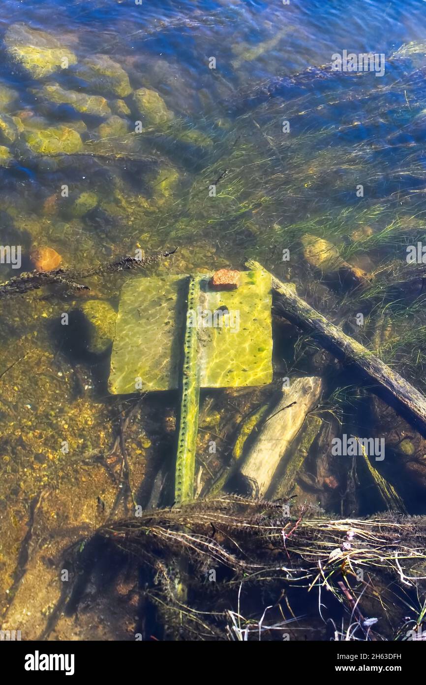An old sign thrown into water at a shoreline Stock Photo - Alamy
