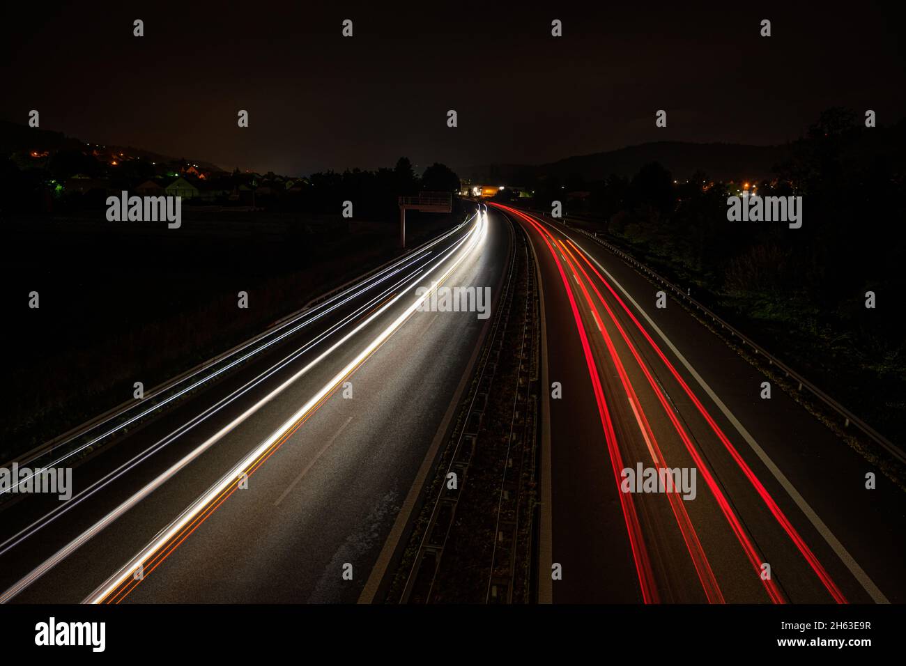 Motorway in night with red and white car light trails glowing Stock Photo - Alamy