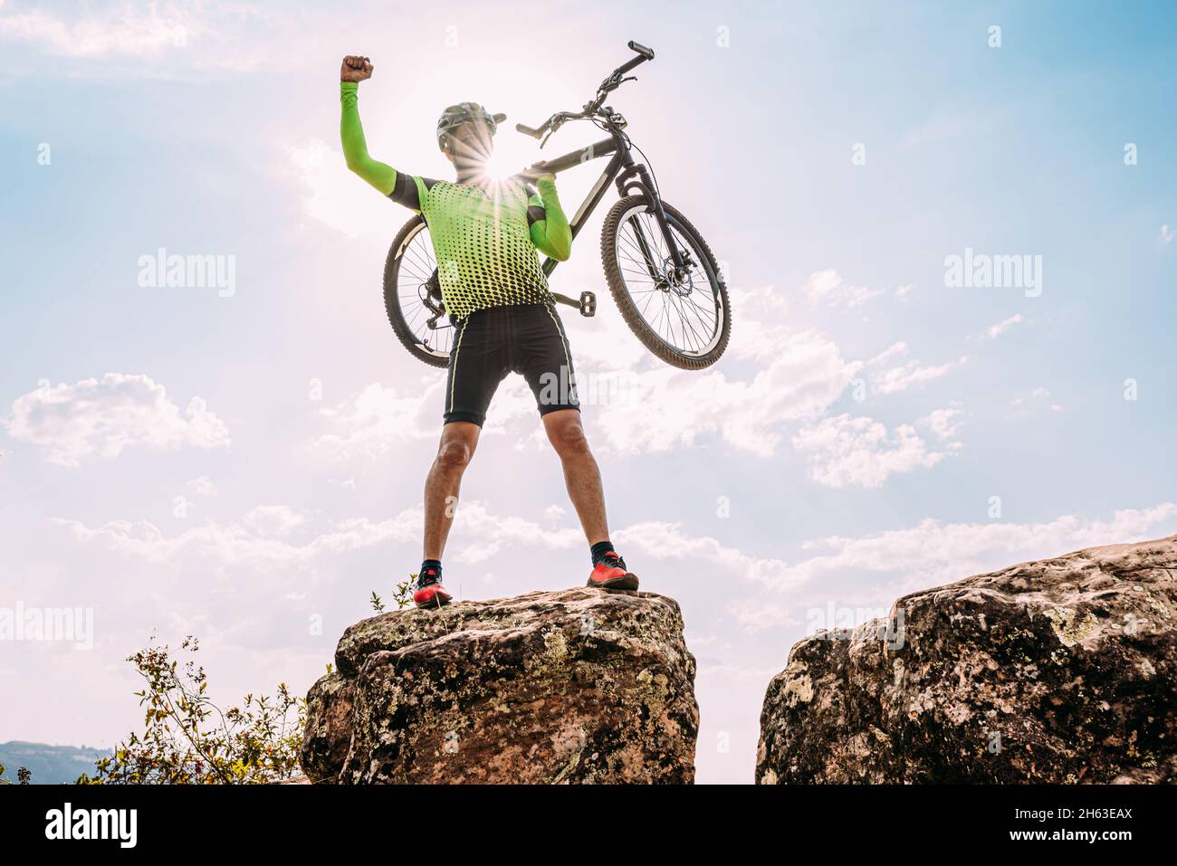 Latin thrilled male cyclist carrying his bike above his head after ...