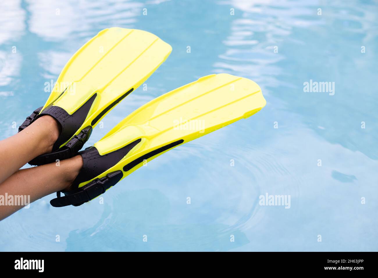 Female legs in flippers on blue water background. Concept of summer ...
