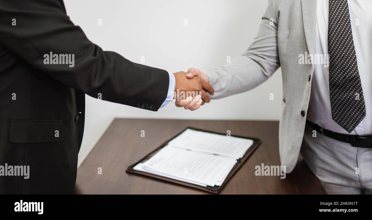 Latin business men making handshake after closed deal at desk in the ...