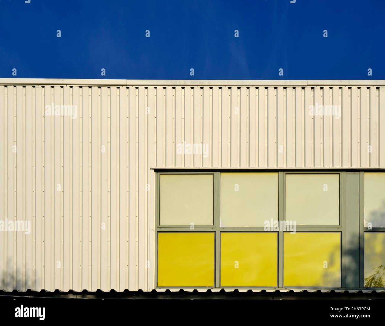 white warehouse with yellow windows,blue sky Stock Photo - Alamy