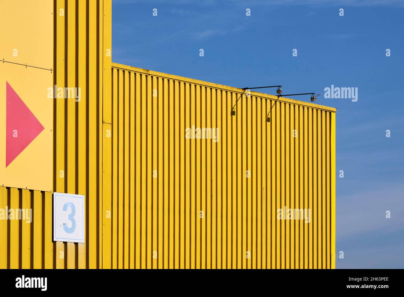 red arrow,yellow warehouse,blue sky,industrial park Stock Photo - Alamy