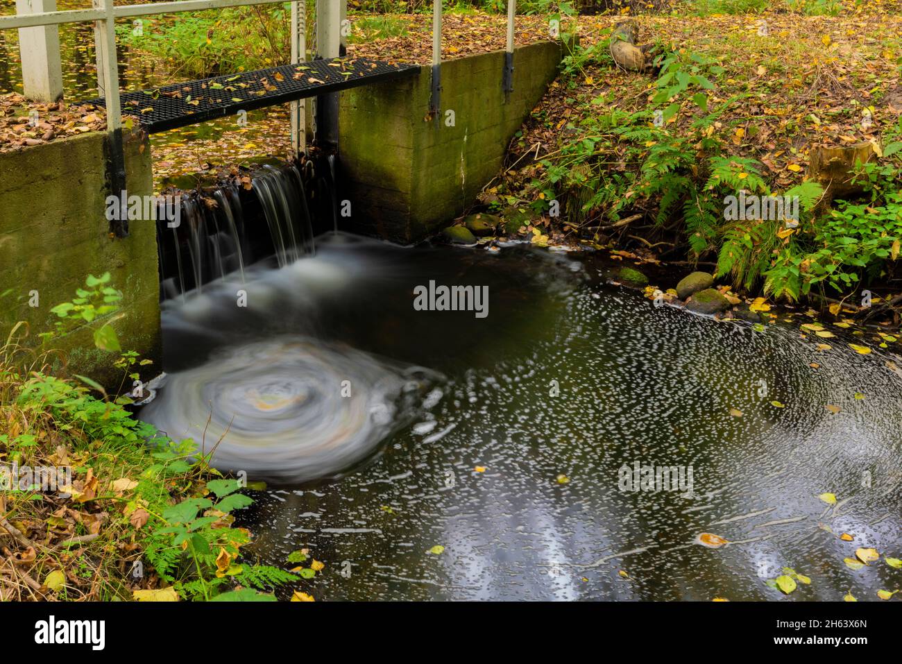 long exposure of a small river at a weir in the forest in autumn Stock ...