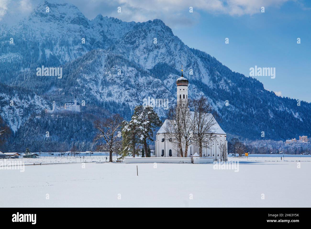 snow-covered landscape with st. koloman church against neuschwanstein ...