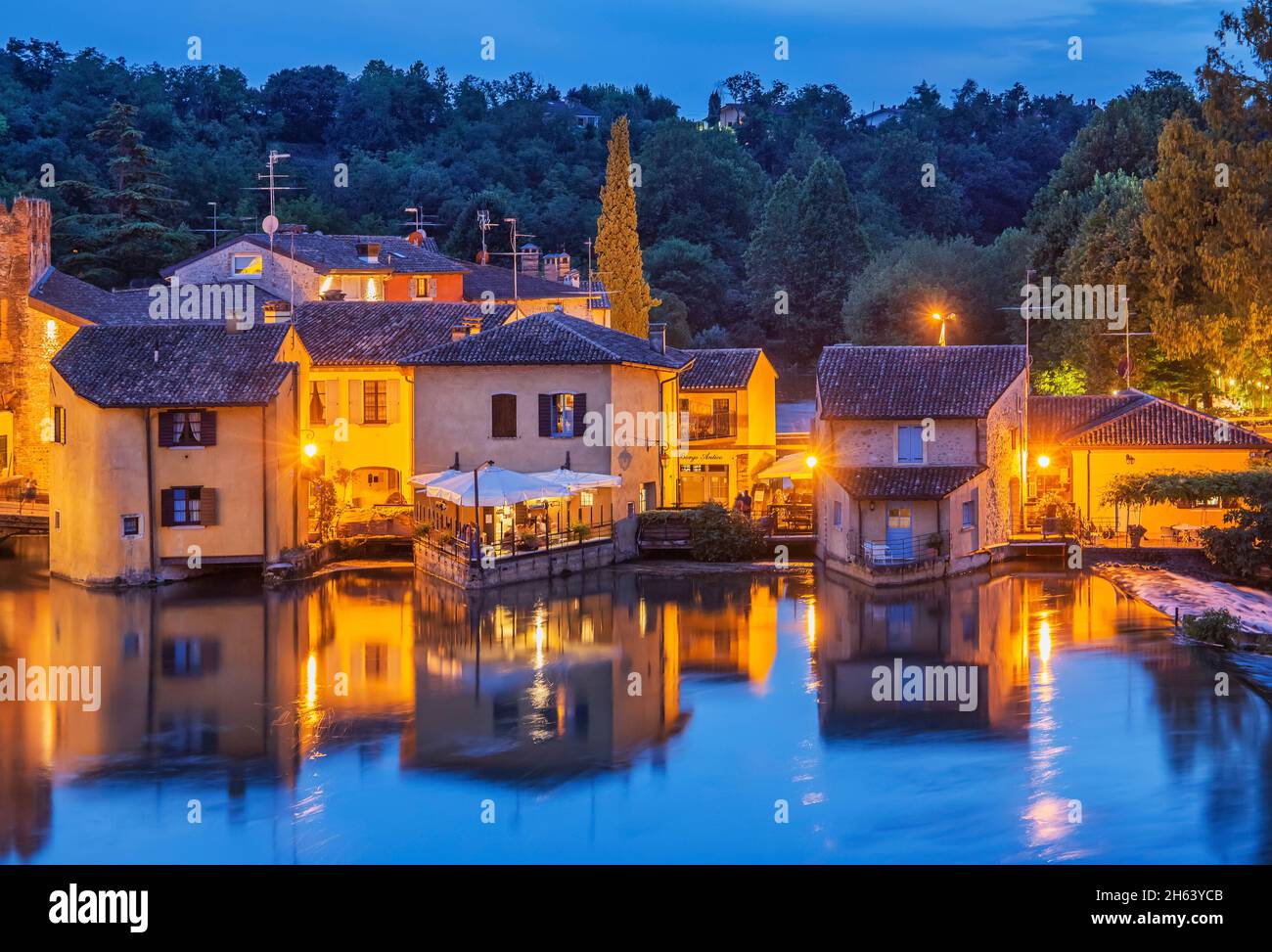 view of the historic village on the mincio river at dusk,borghetto ...
