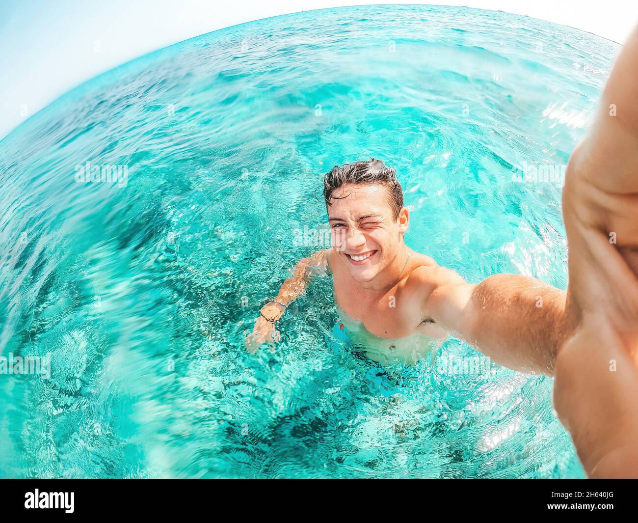 portrait of happy young man taking a selfie of him in the beach in a ...