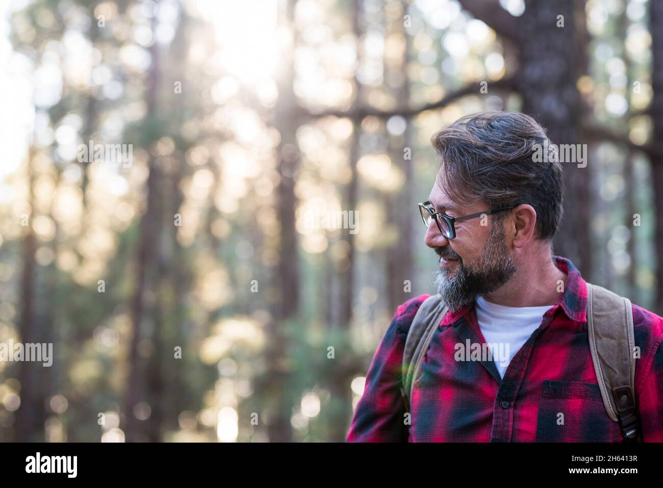 man hiking and enjoying in a woods forest location. side view of a man ...