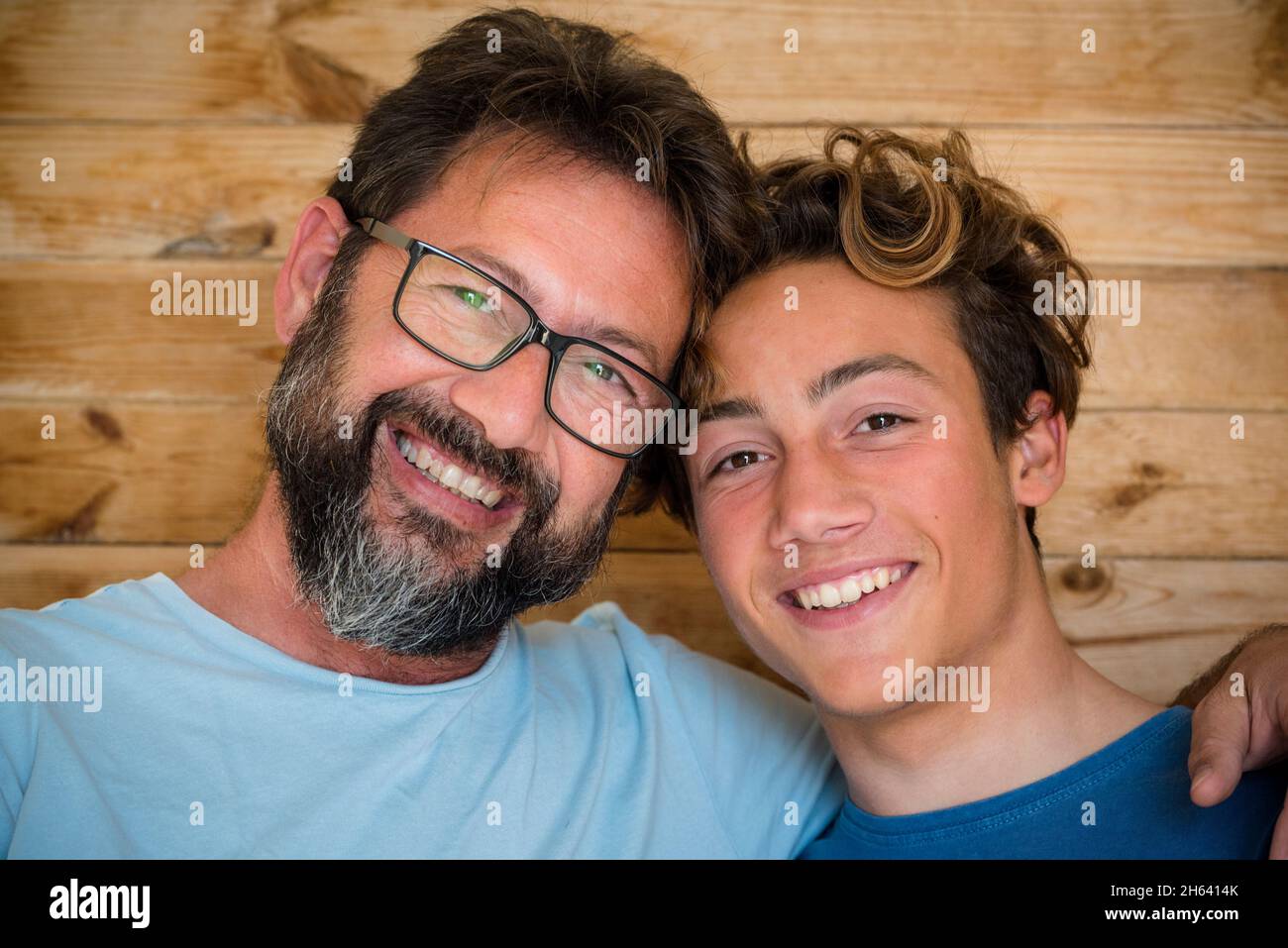 father and son cheerful portrait with wood background - happy caucasian ...