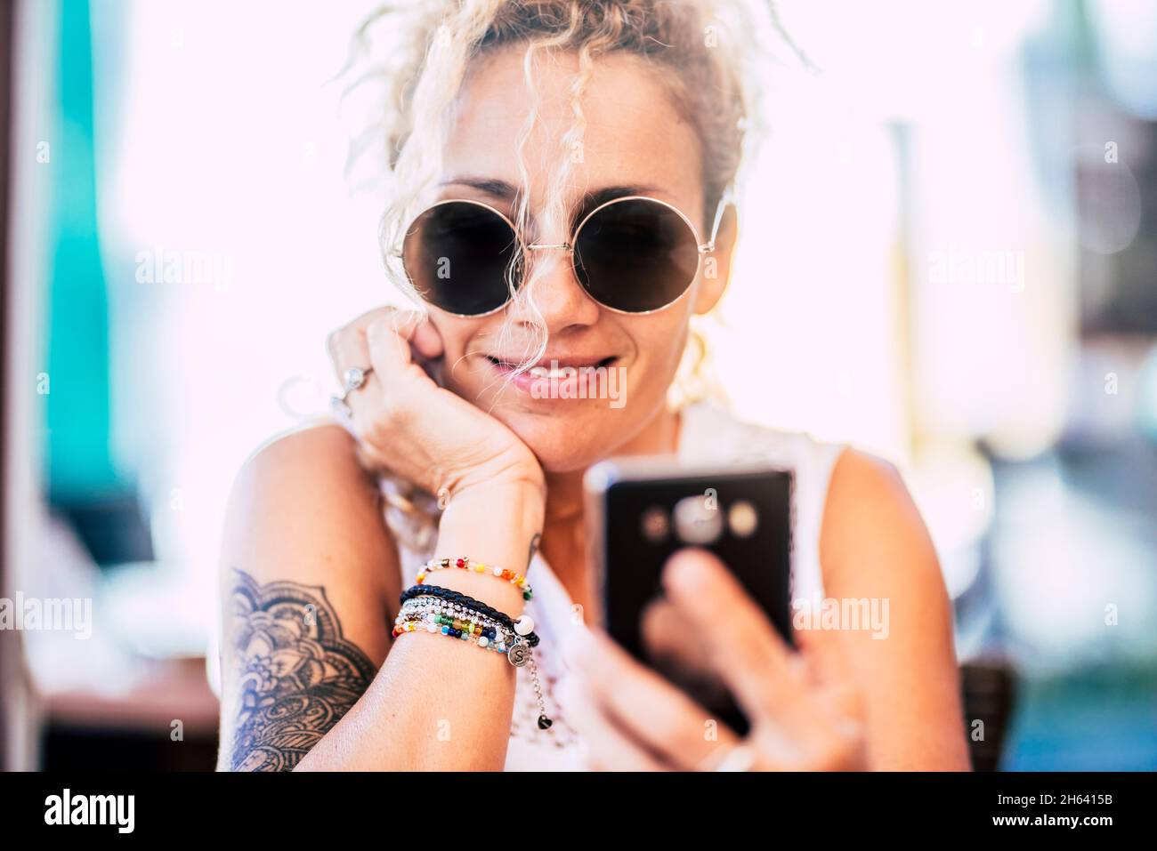 portrait of cheerful modern young woman using cell phone smiling ...