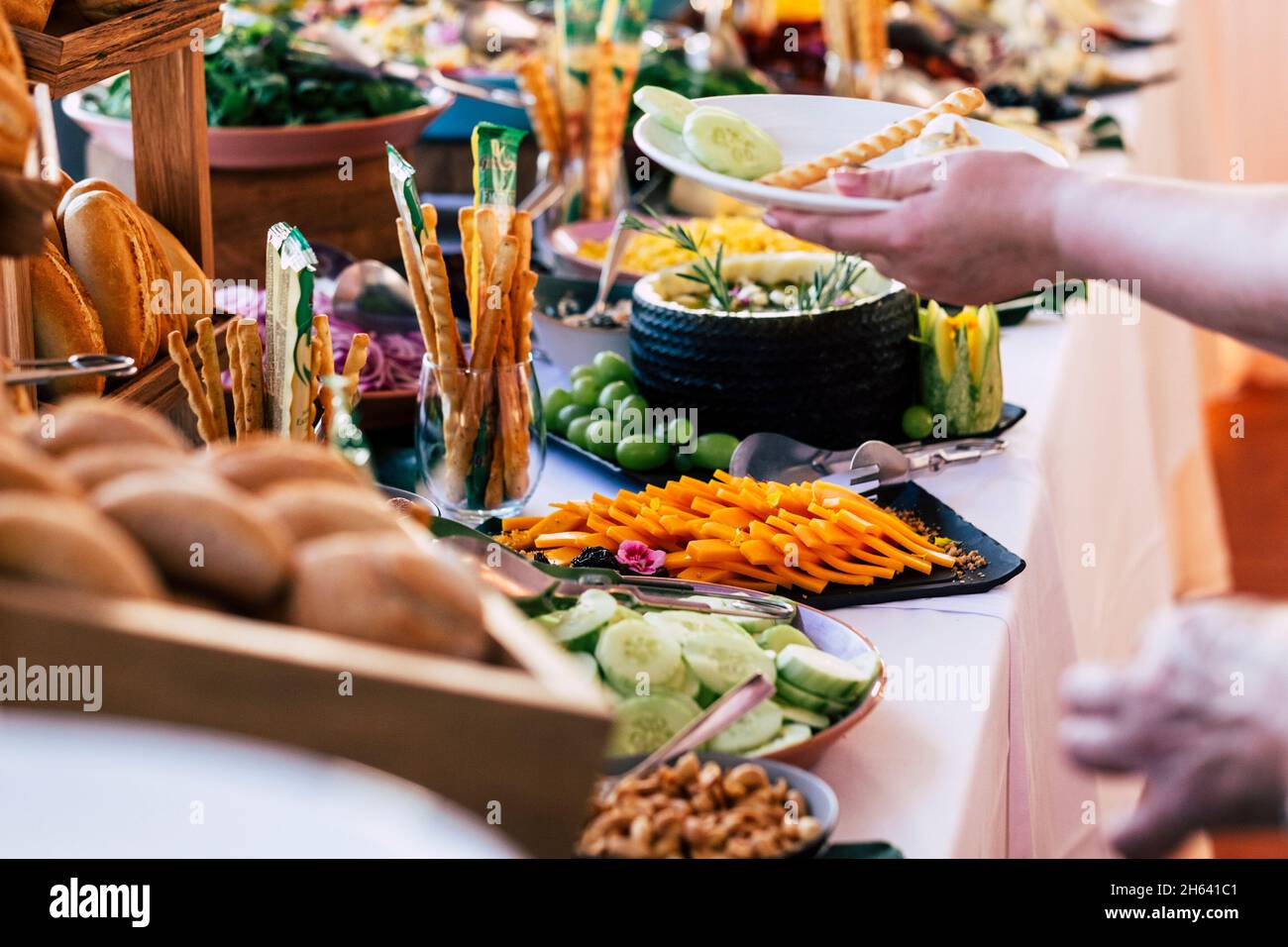close up of people taking food from table at event party with catering ...