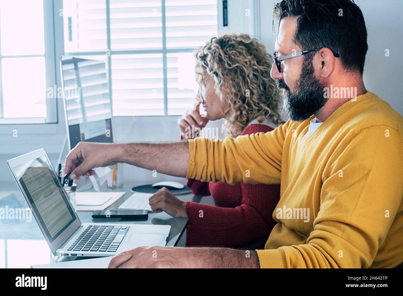 adult caucasian couple at home in smart working and remote work job ...