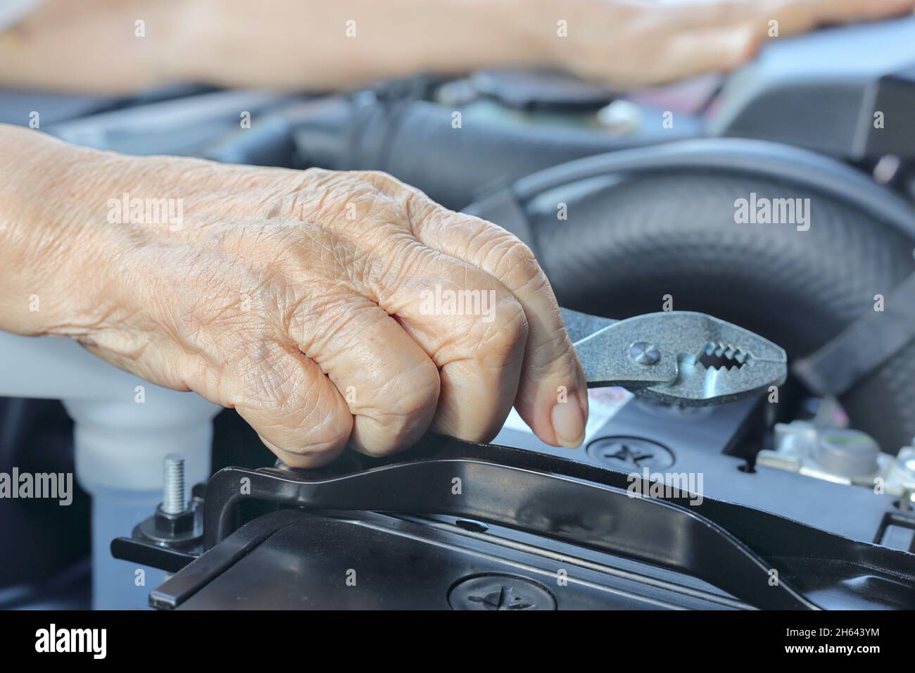Elderly woman repairing her car Stock Photo - Alamy