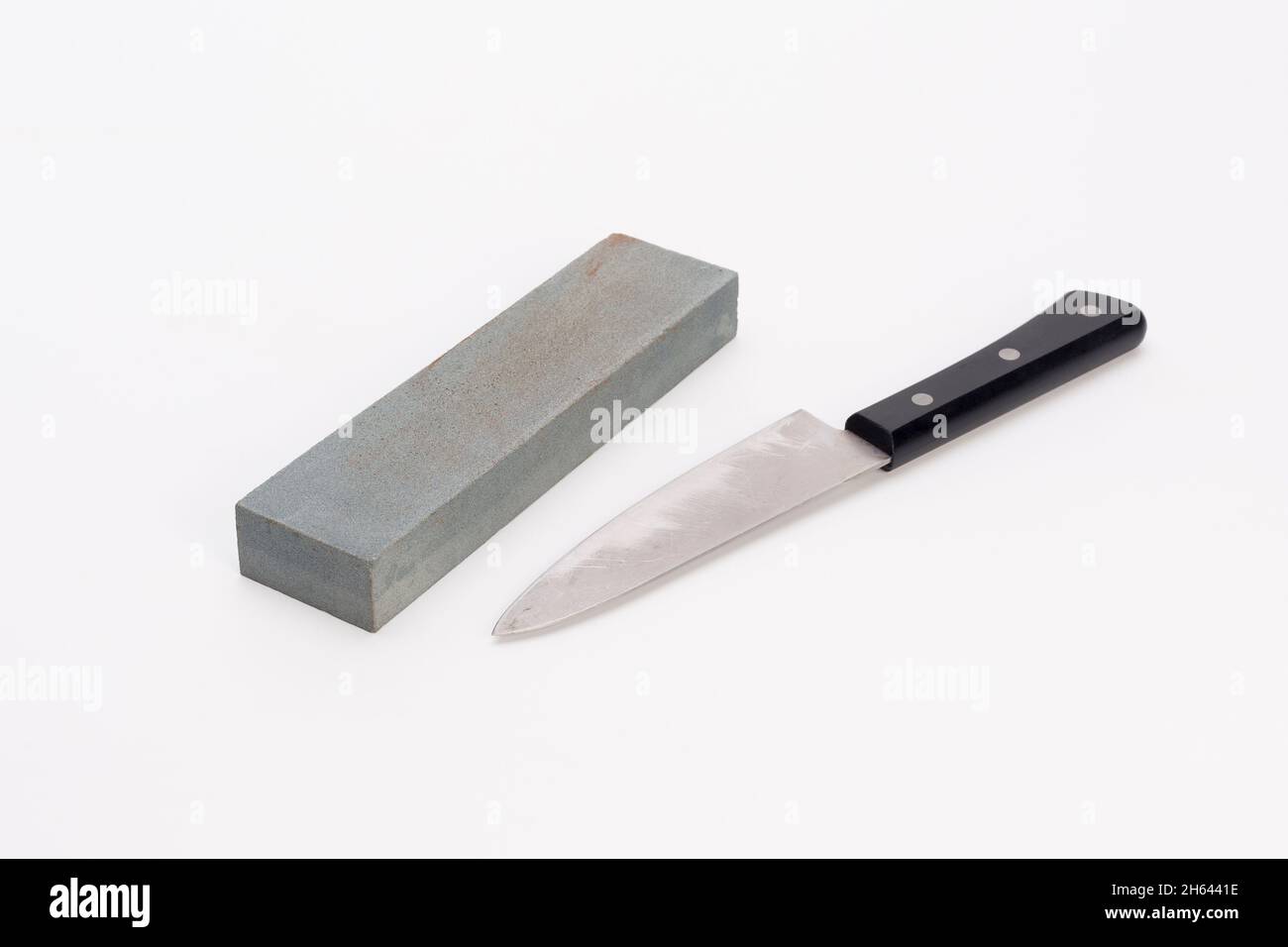 Whetstone and knife on white background Stock Photo - Alamy