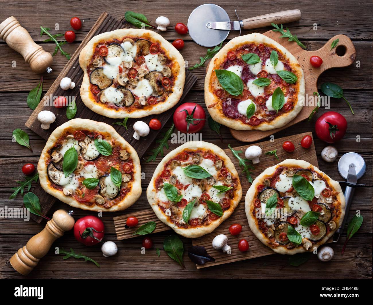 Homemade traditional italian pizzas on old wood background overhead ...