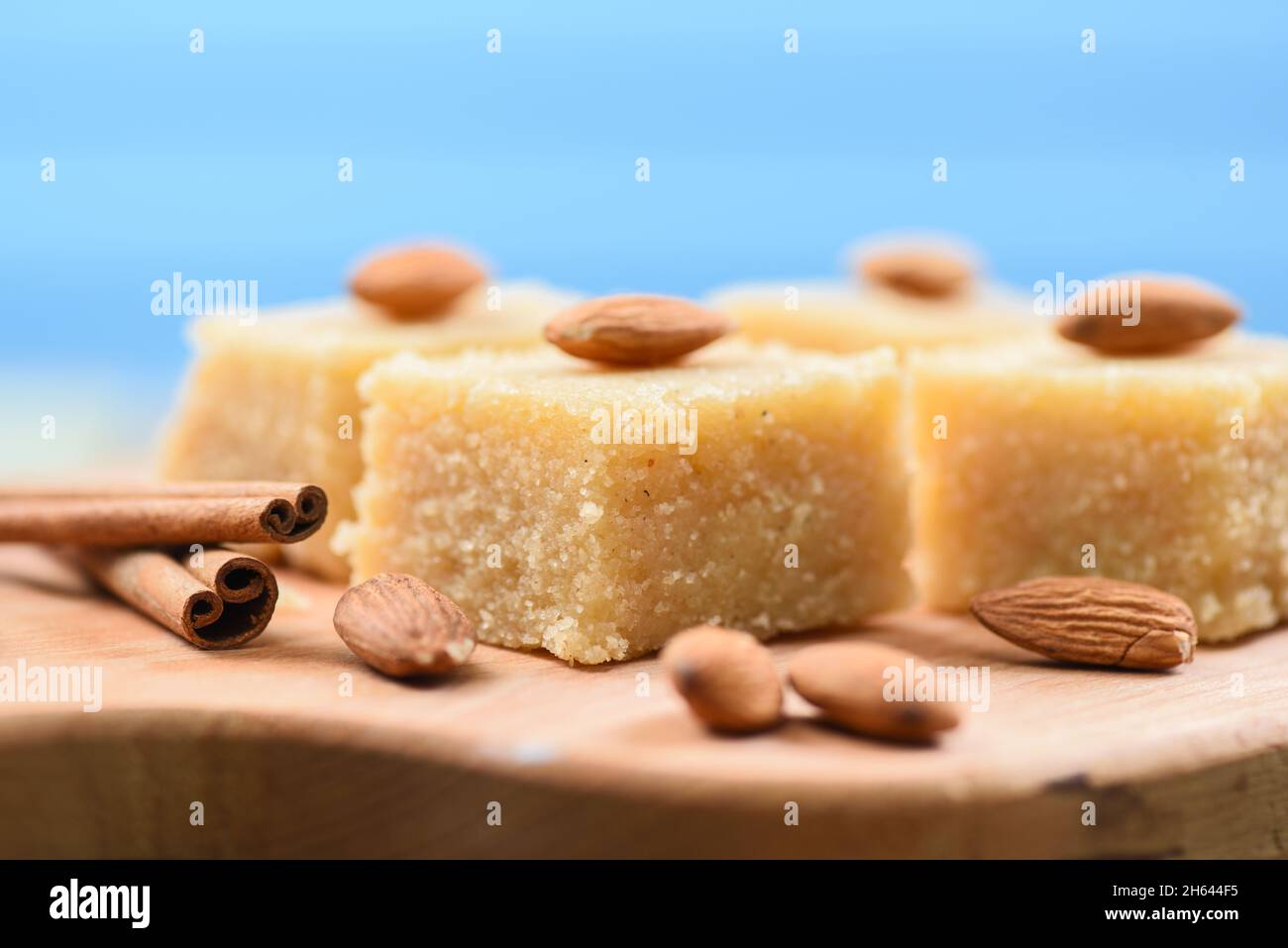 Traditional Indian dessert halava with almonds on wooden board closeup ...