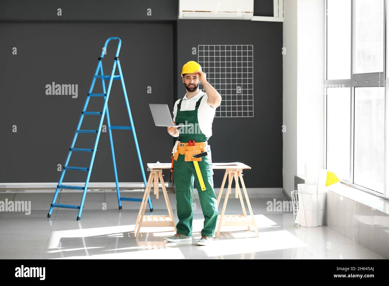 Construction worker with laptop in room Stock Photo - Alamy