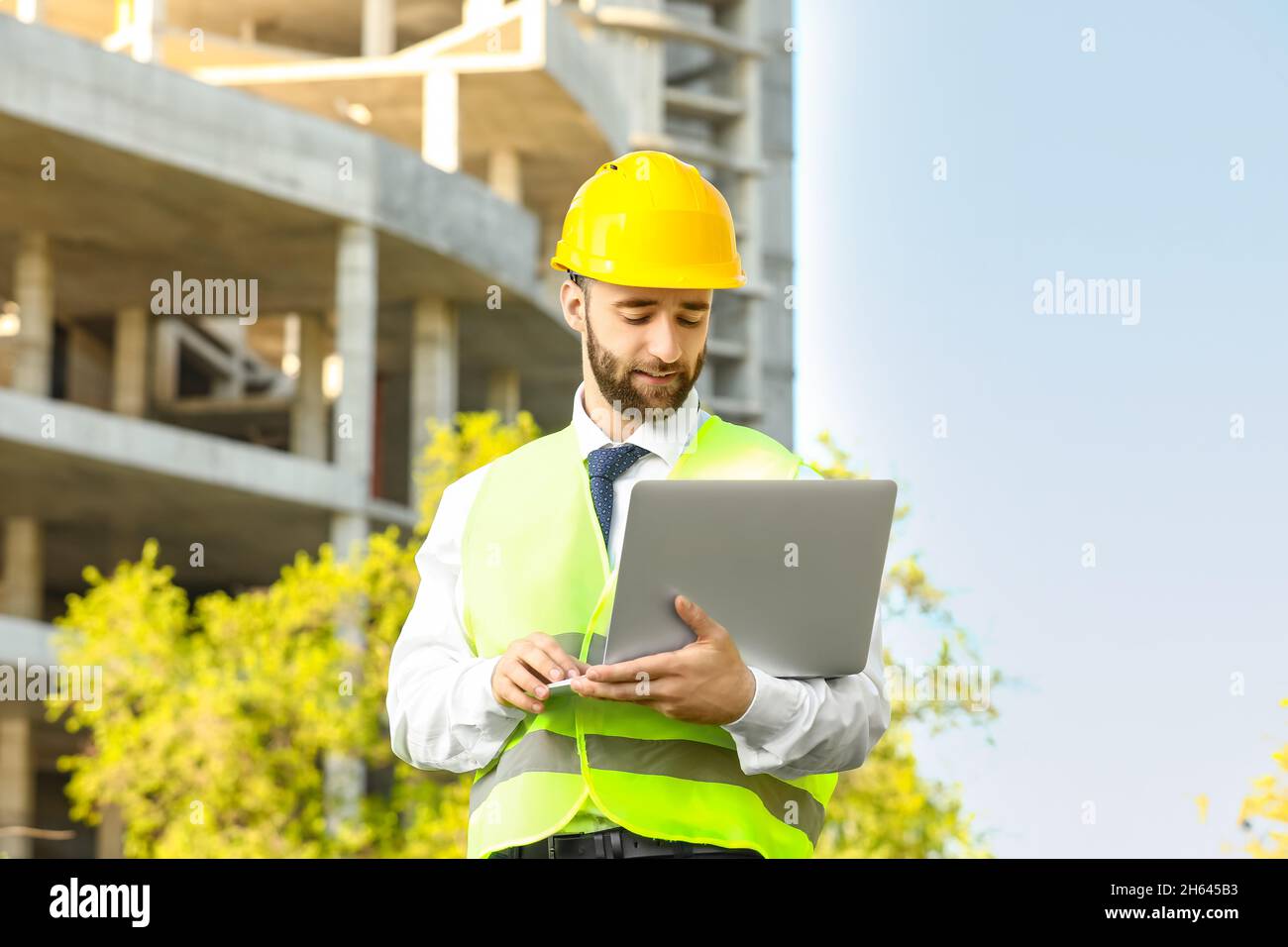 Construction worker using laptop outdoors Stock Photo - Alamy