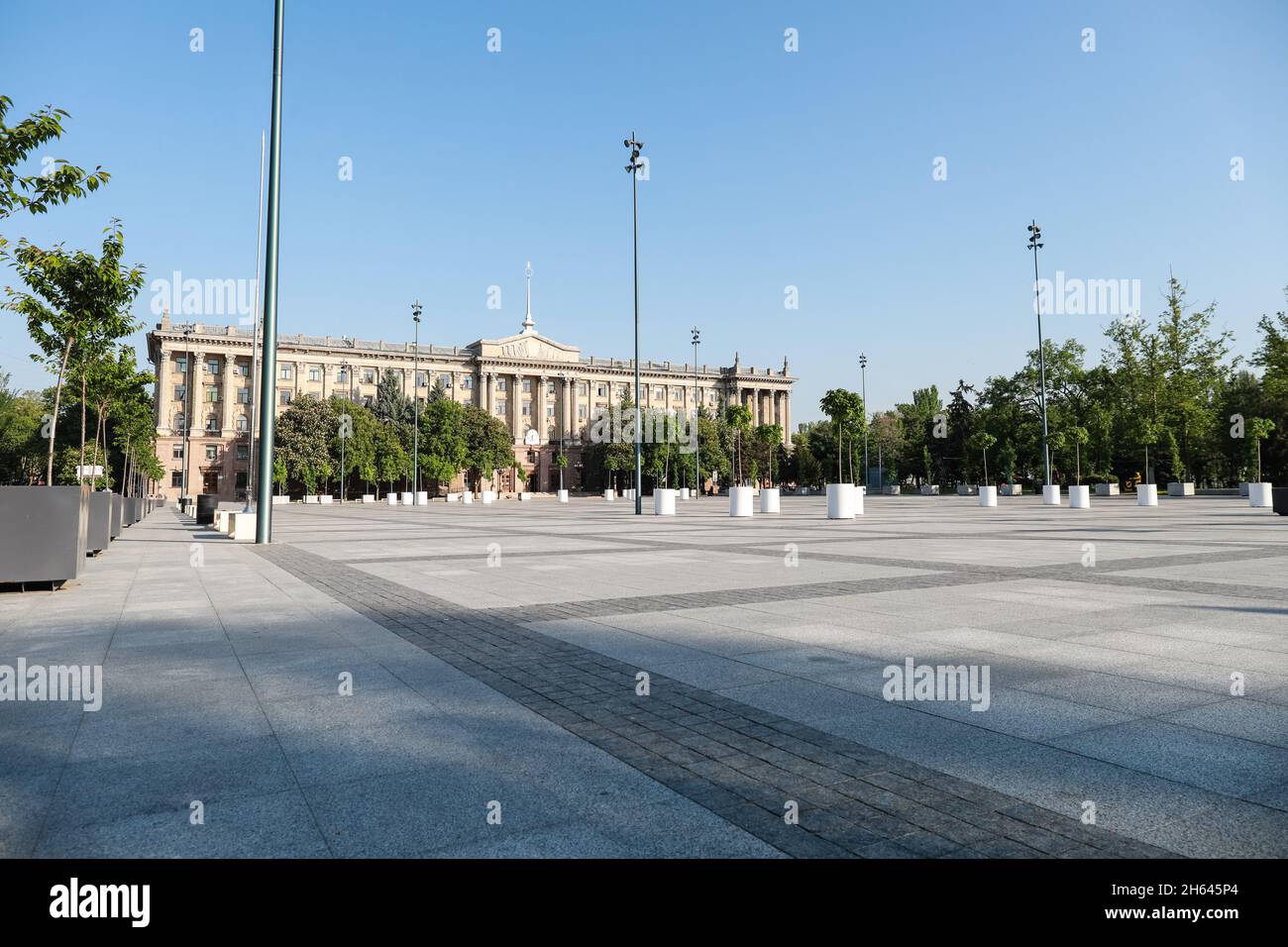 View of modern square with green trees and old building Stock Photo - Alamy