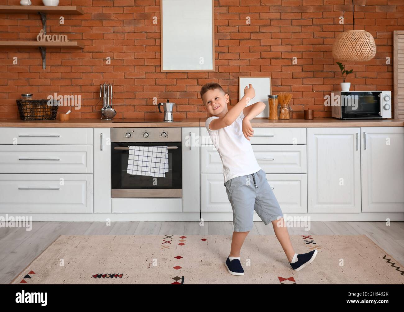 Cute little boy dancing in kitchen Stock Photo - Alamy