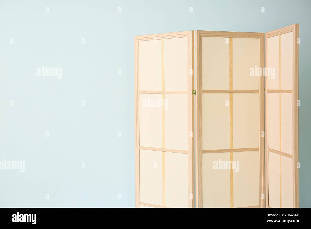 Beige folding screen near blue wall Stock Photo - Alamy