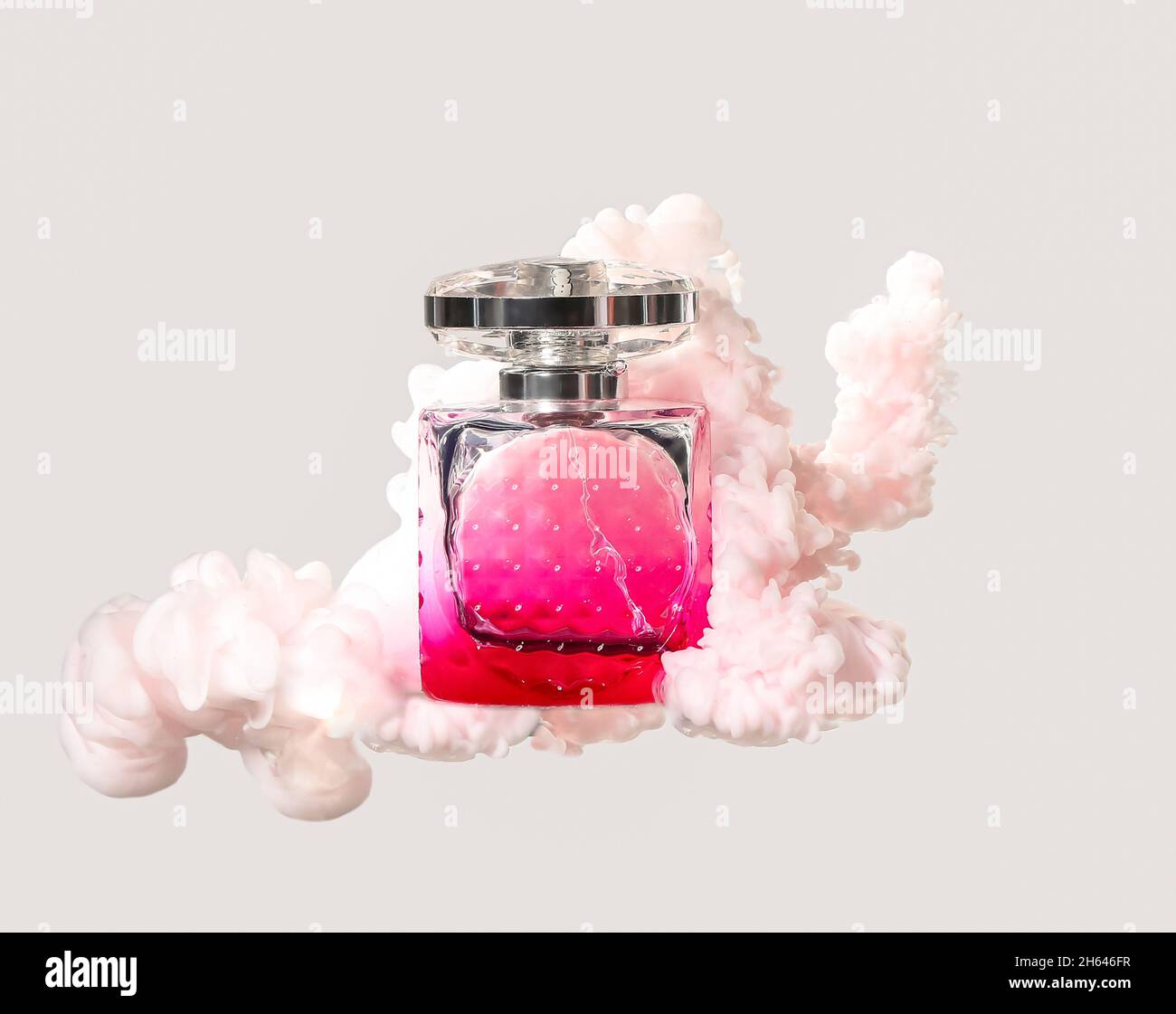 Perfume bottle in light smoke on grey background Stock Photo - Alamy