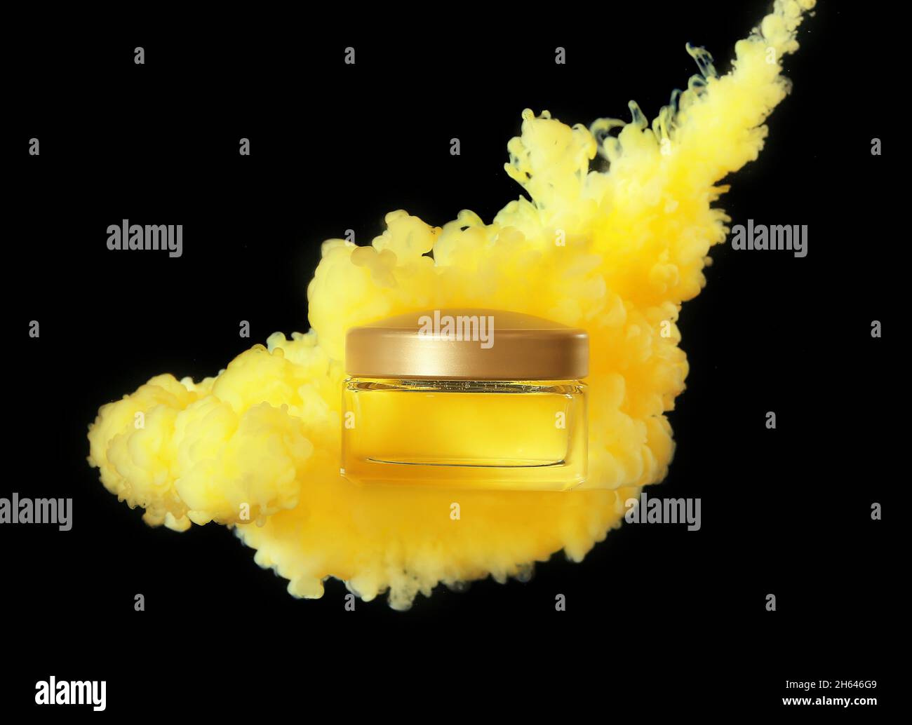Jar of cosmetic product in yellow smoke on black background Stock Photo ...