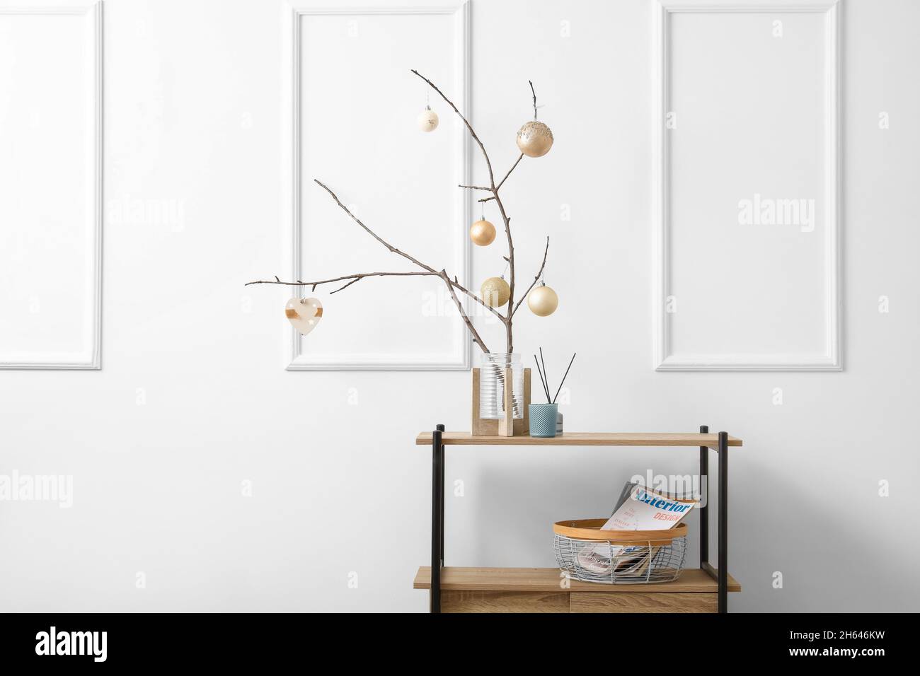 Tree branches with Christmas balls in stylish room interior Stock Photo ...