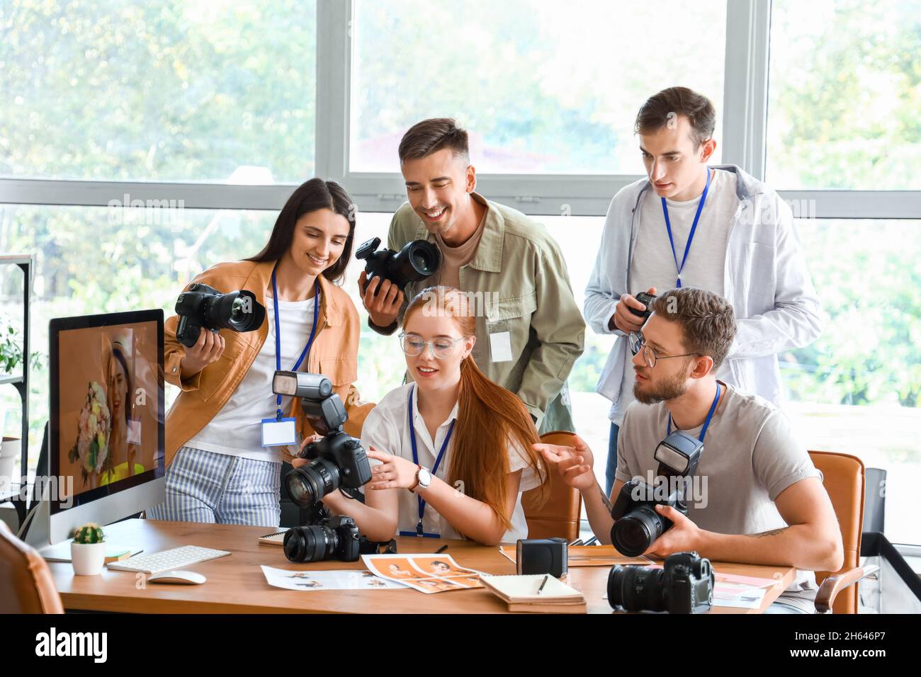 Professional photographer teaching young people in studio Stock Photo ...