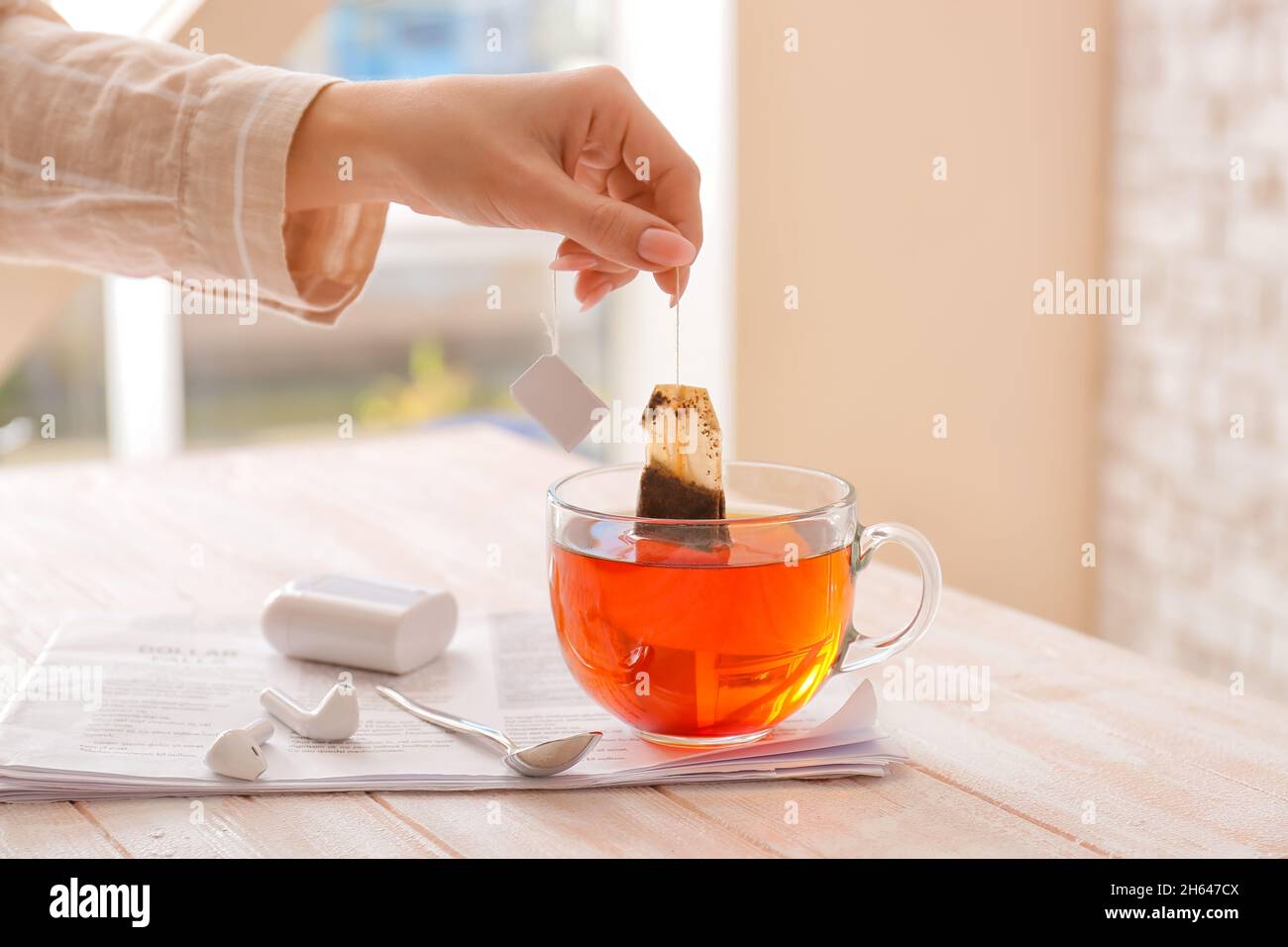 Female hand dipping tea bag in hot water at table in cafe Stock Photo ...