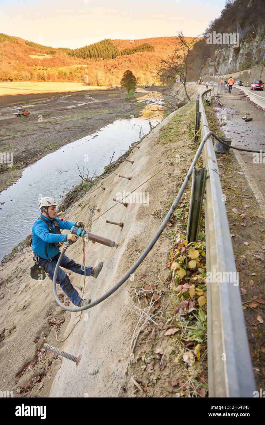 Schuld, Germany. 09th Nov, 2021. Workers erect a retaining wall facing ...